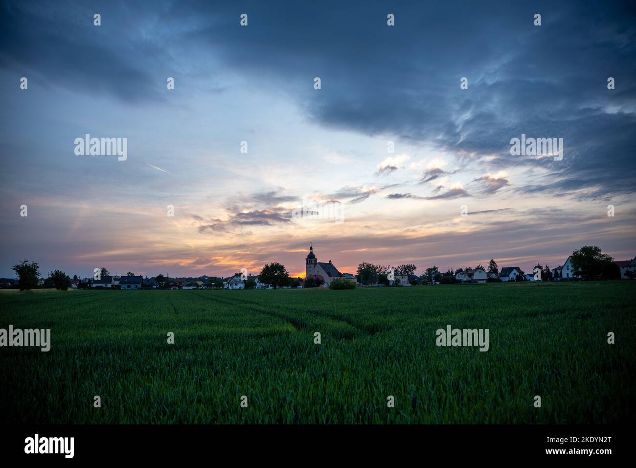 The grass field before small medieval town buildings under the blue ...
