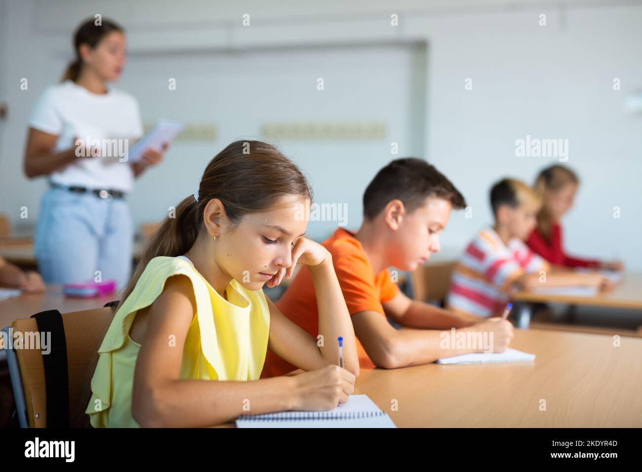 Portrait of school girl who writing exercises at lesson in school Stock ...