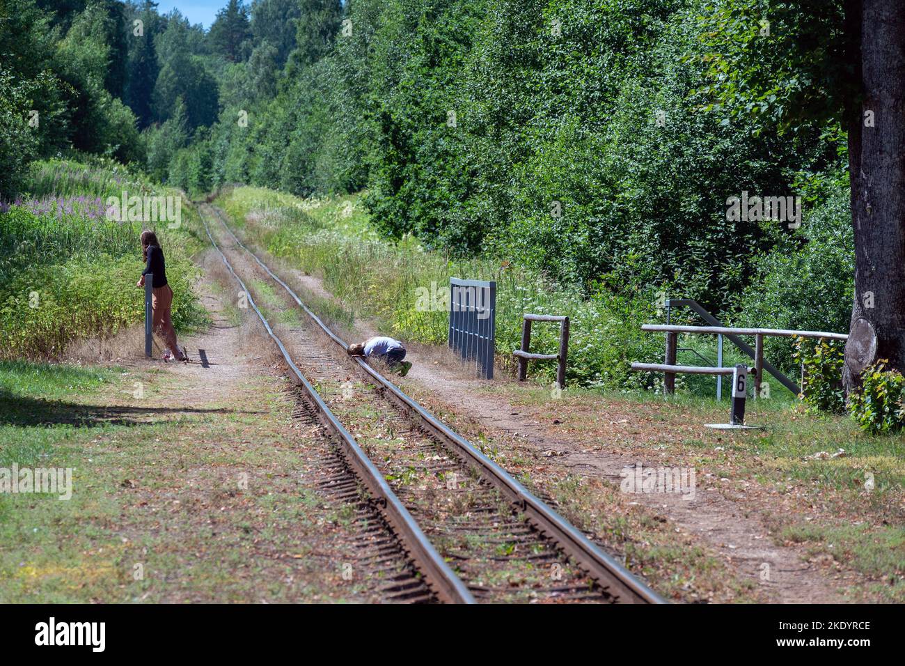 Child listens to the sound of an oncoming train on the rail Stock Photo ...