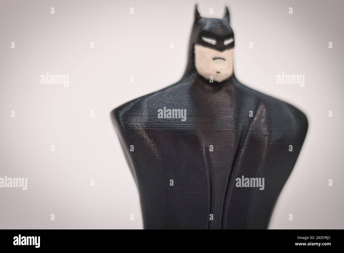 A closeup shot of a 3d printed batman toy figure isolated on an empty ...