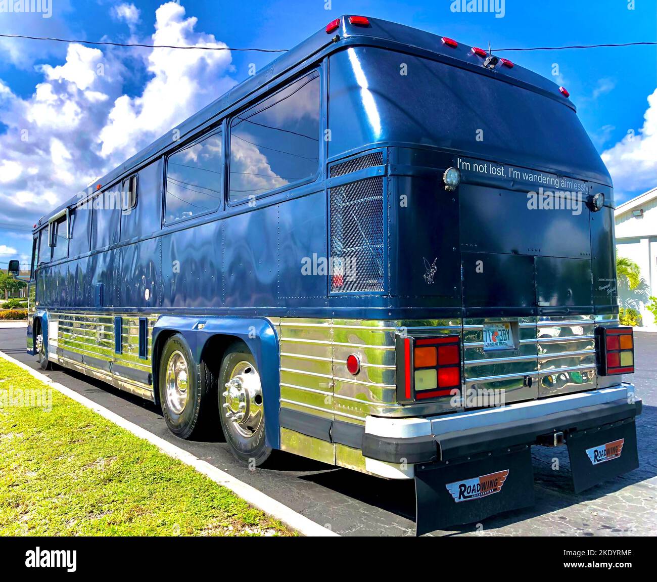 The back of the 1989 MCI dark blue bus on a sunny day with the clear ...