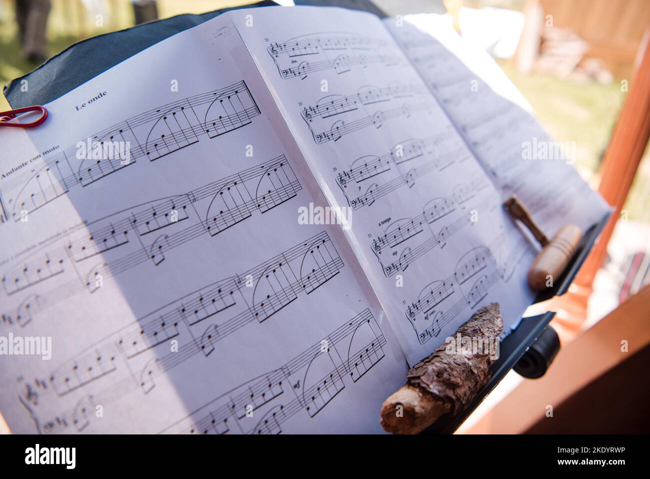 A closeup of music note sheets on a stand outdoors for a wedding event ...