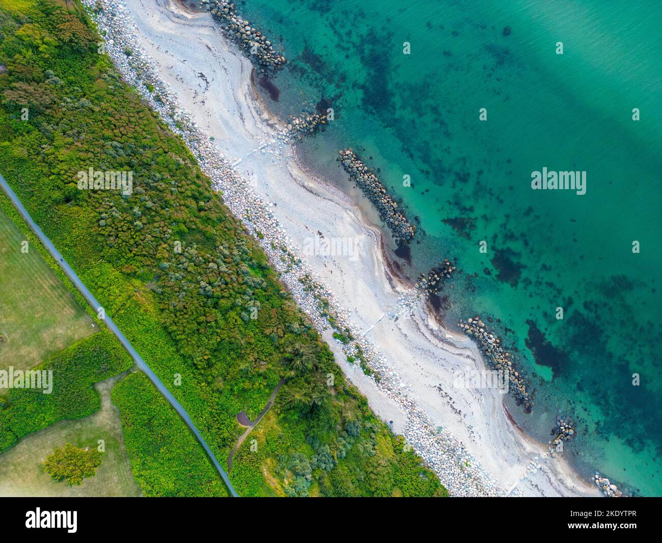 An aerial shot of Gilleleje beach with white sand and blue ocean water ...