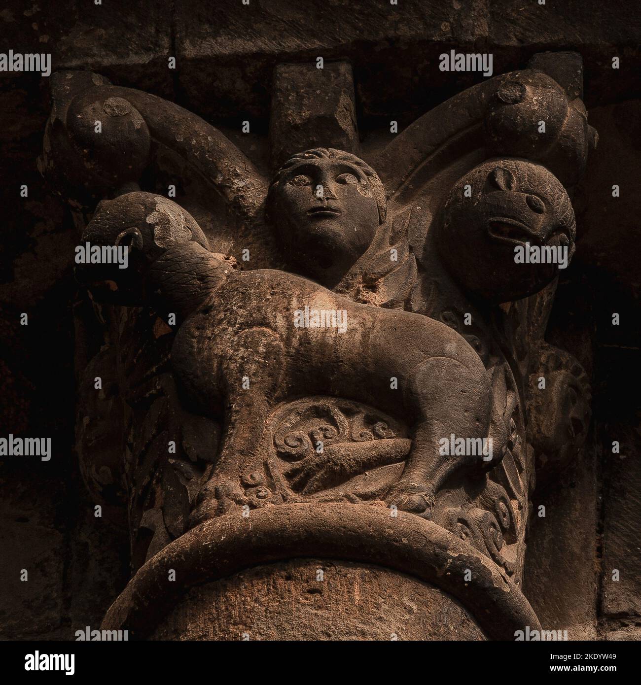 Grotesque round human faces above a standing lion with replaced head ...