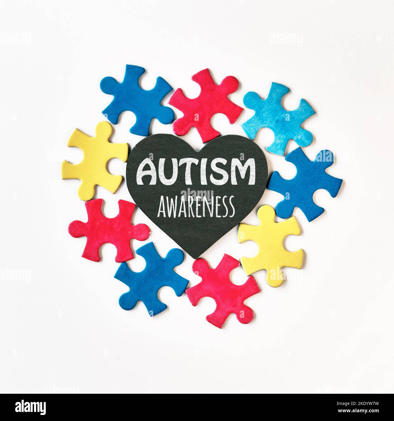Autism campaign symbols. Colorful puzzle pieces around blackboard stone ...