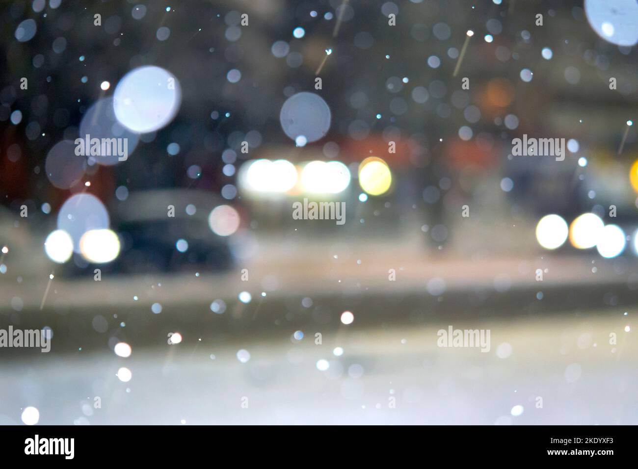 Blurred background. City view, lights, falling snow, night, street ...