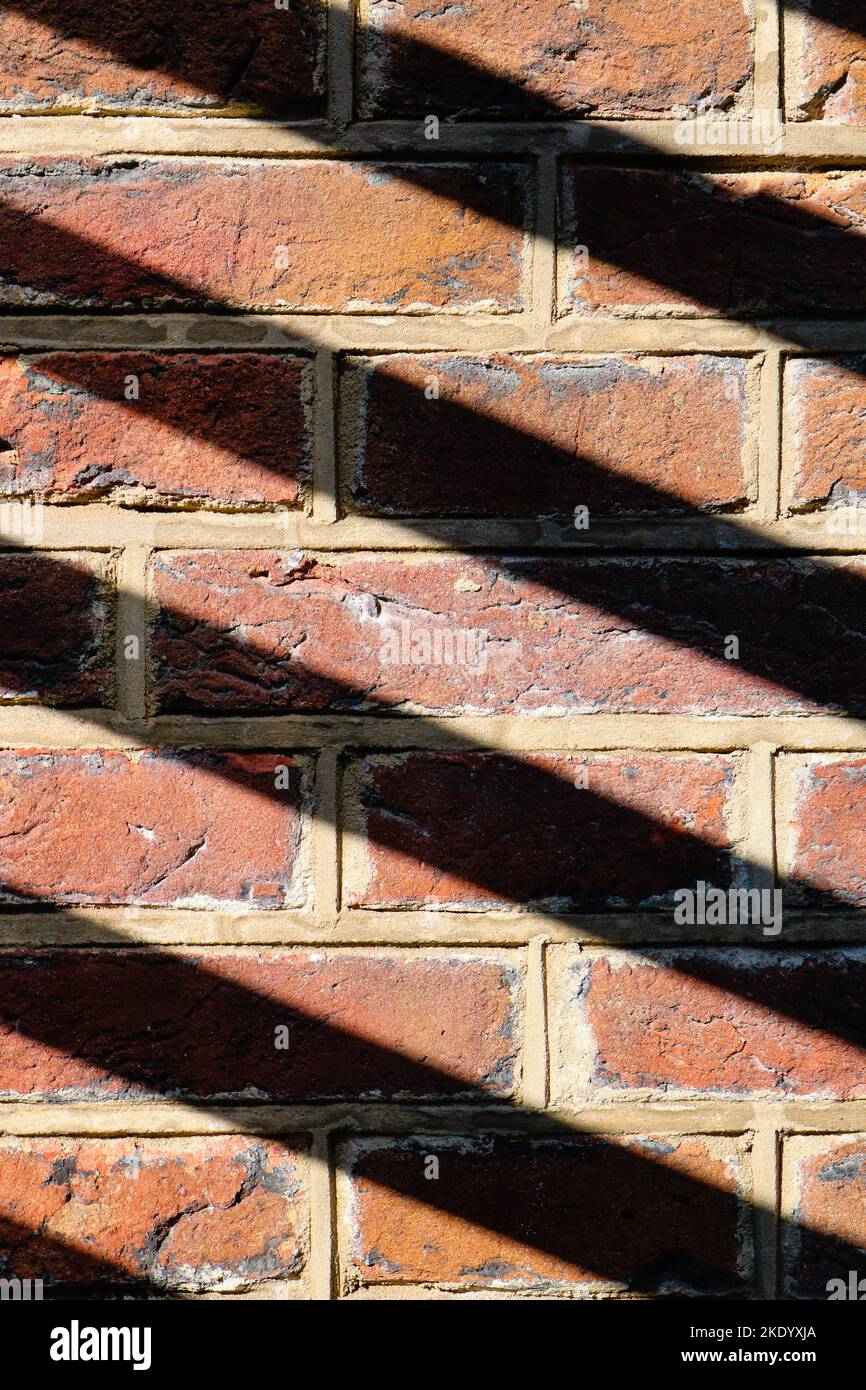 Sunshine casting a shadow pattern on a brick wall Stock Photo - Alamy