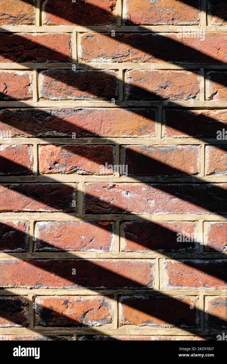 Sunshine casting a shadow pattern on a brick wall Stock Photo - Alamy