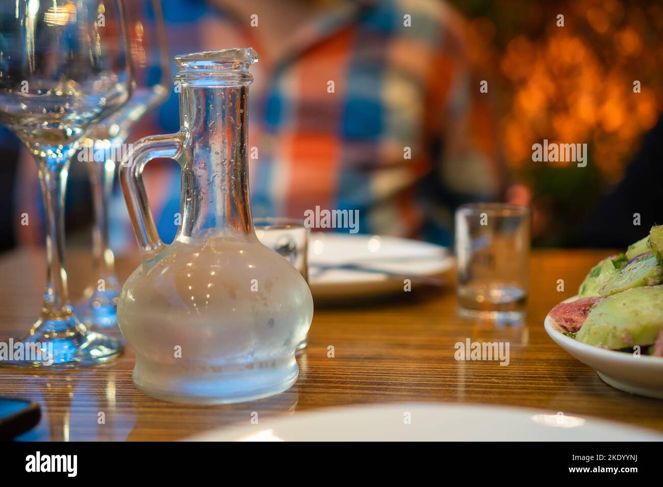 Close-up of a small decanter with vodka or a cup covered with water ...