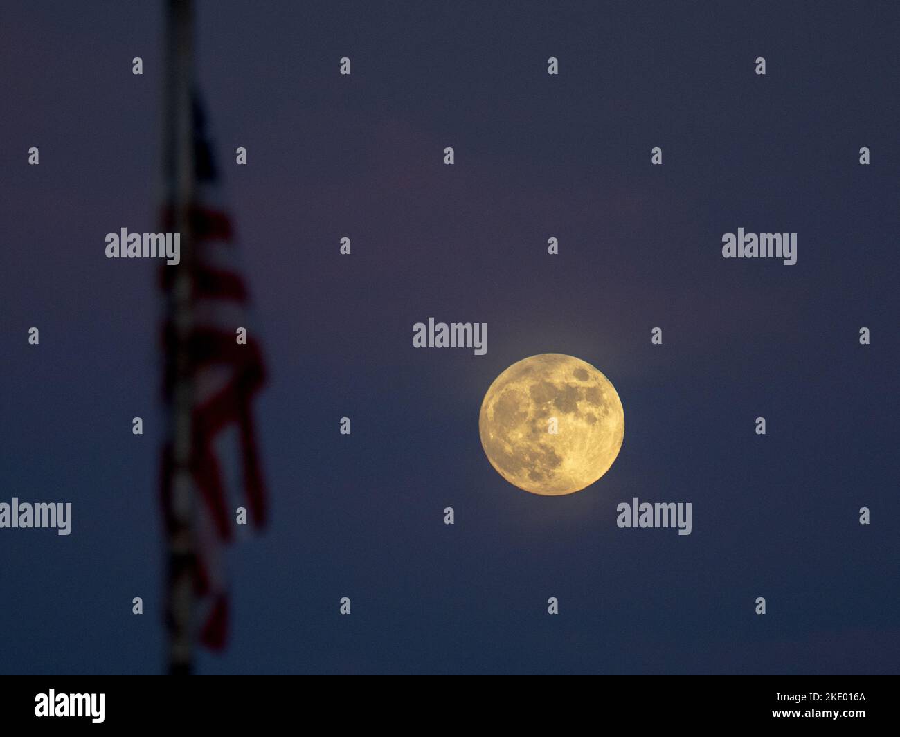 A full moon glows with a yellow tint as it rises above Phoenix Arizona ...