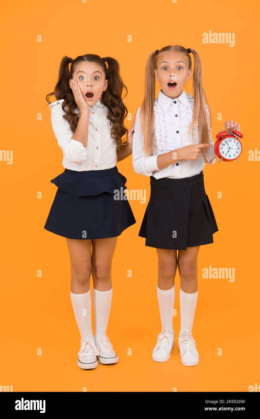 OMG. Got a surprise. Surprised schoolgirls checking time on yellow ...