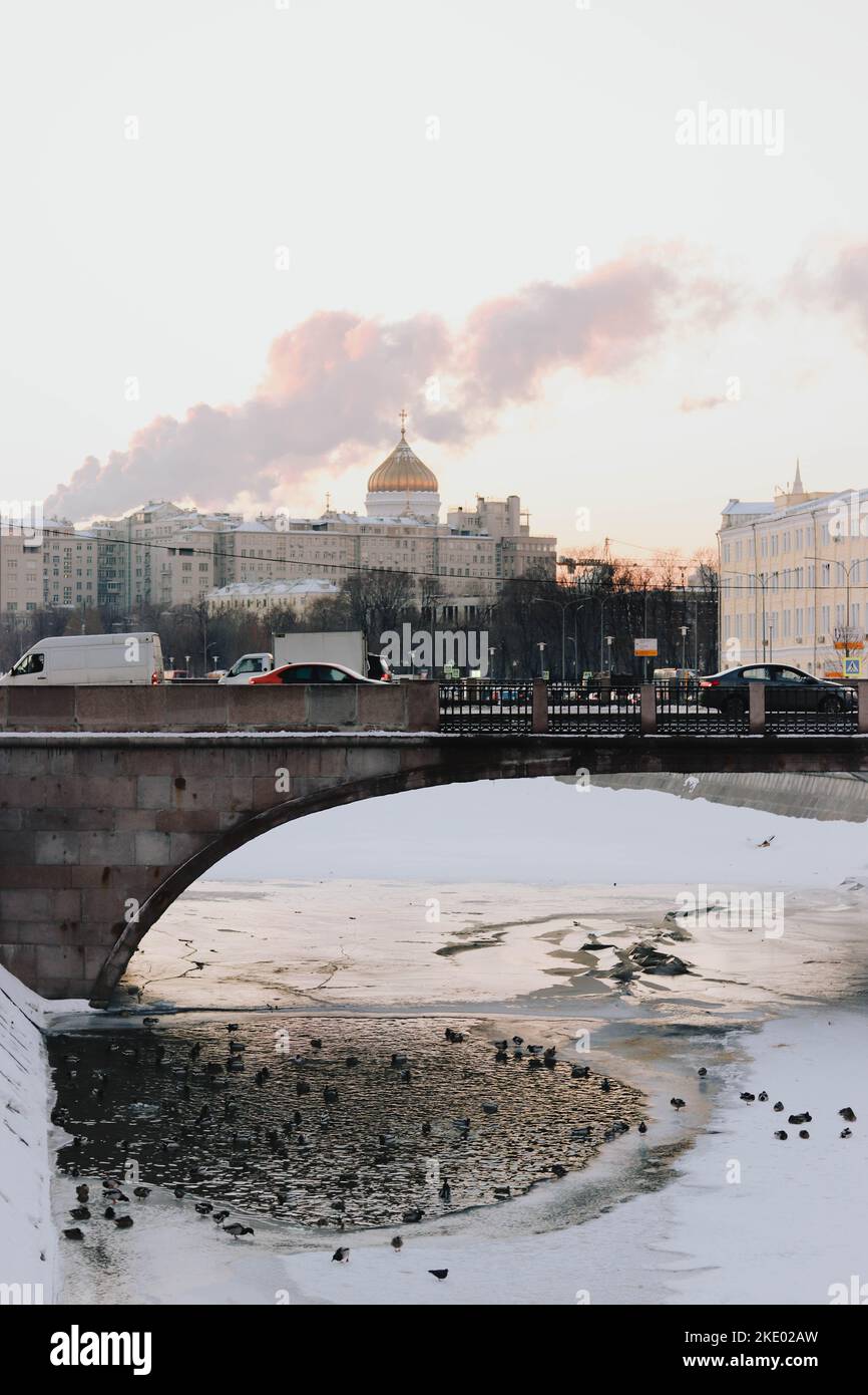 A vertical shot of a bridge crossing the frozen Moskva river with the ...