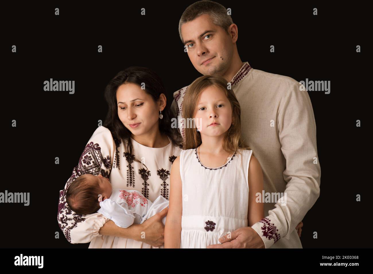 A happy Ukrainian family with children in national clothes on a black ...