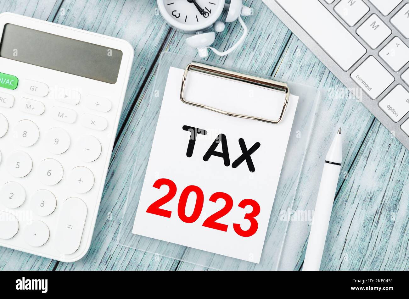 Tax 2023 text on clipboard with pen and calculator on wooden background ...
