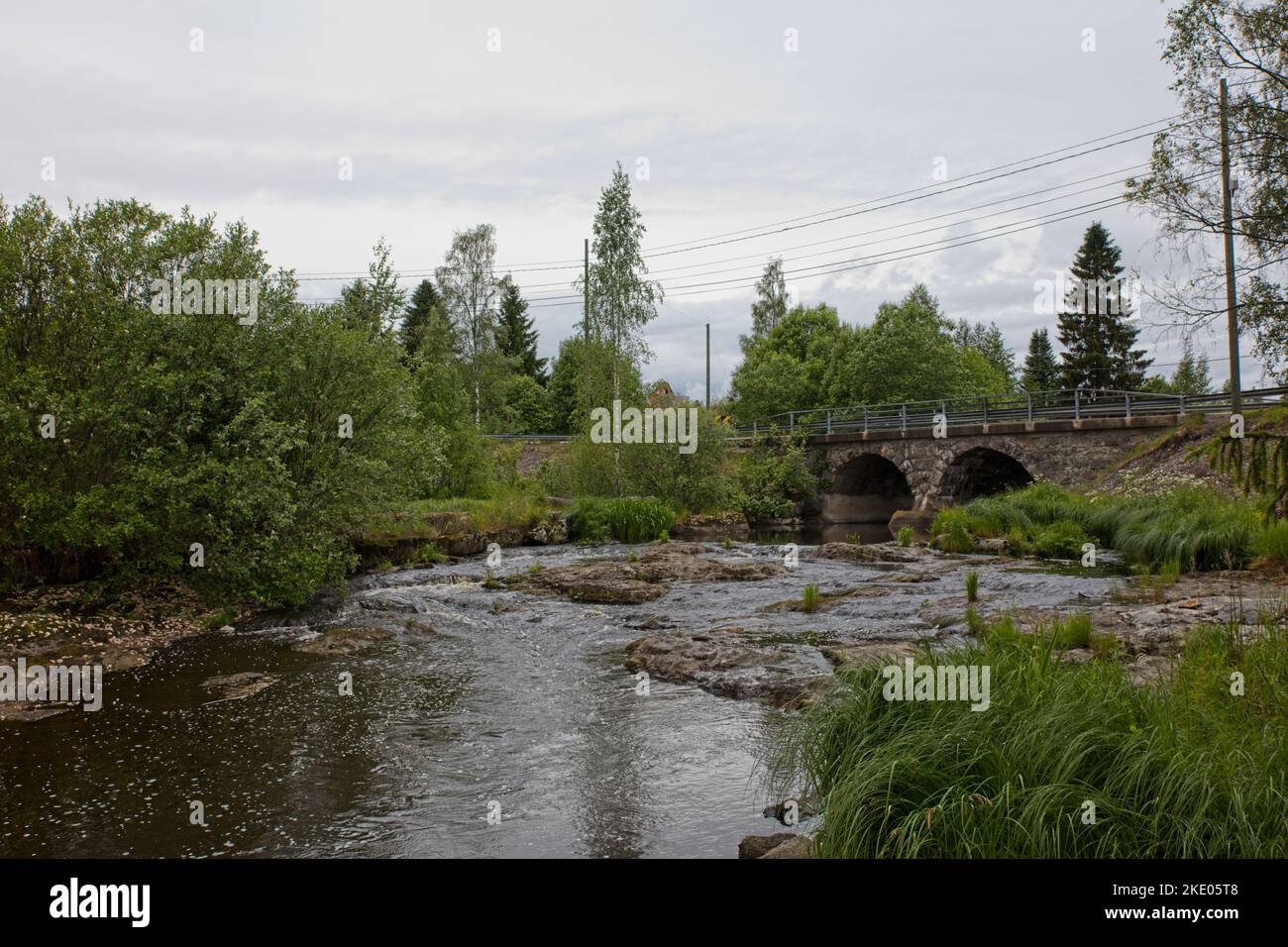 Two arch old stone bridge over Hirvihaaranjoki river in cloudy weather ...