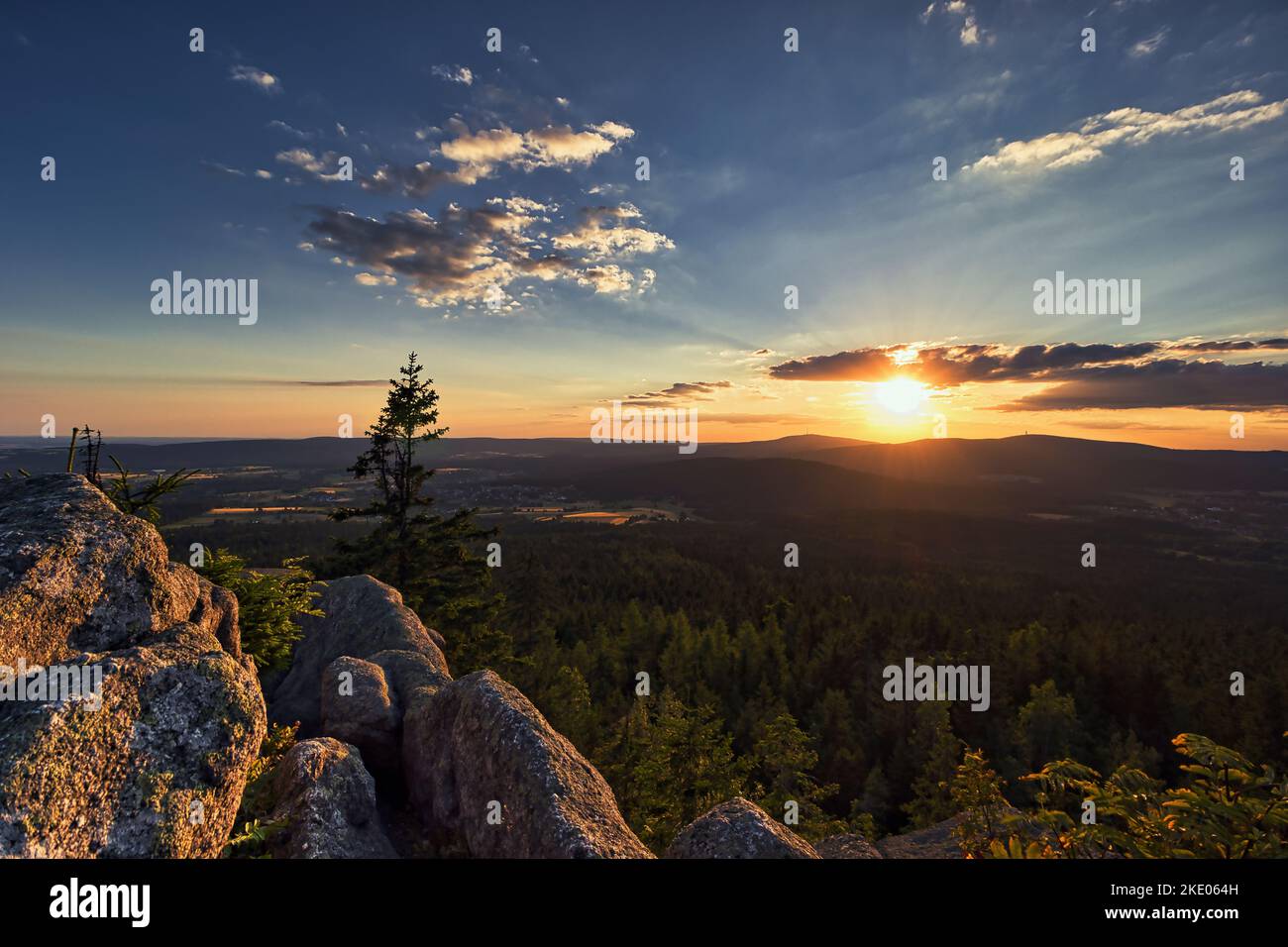 A cloudy sunset sky over forested mountains Stock Photo - Alamy
