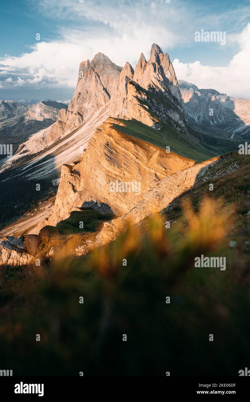 A vertical shot of the rocky Seceda mountain in Italy with the sunlight ...