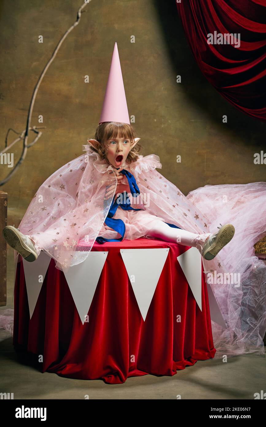 Magic. Little cute girl, kid in image of magical elf posing over dark ...