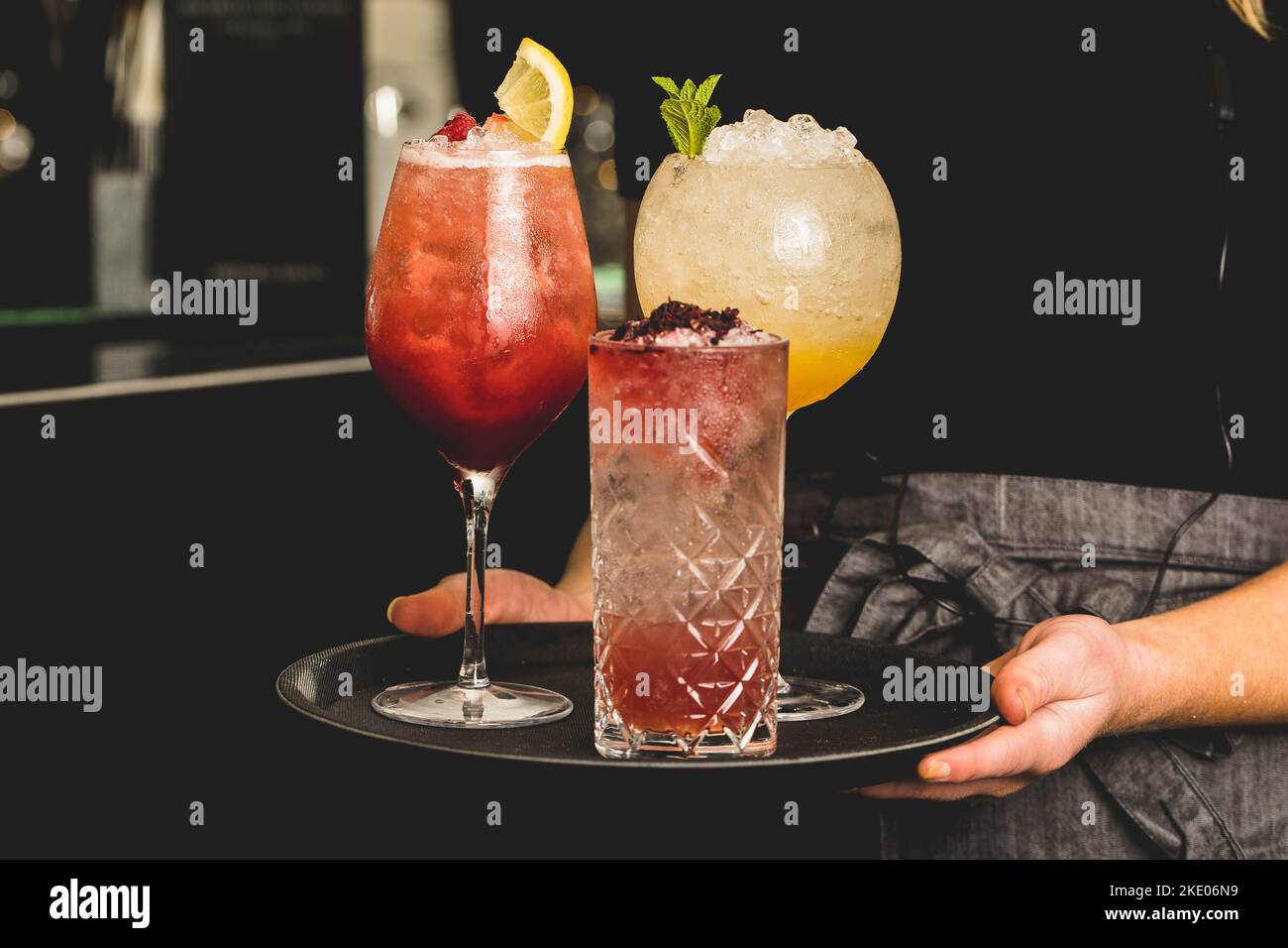 A waiter serving different cocktails on a tray Stock Photo - Alamy