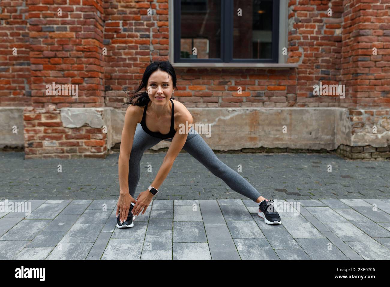 Fitness woman stretching legs doing side lunges before run Stock Photo ...