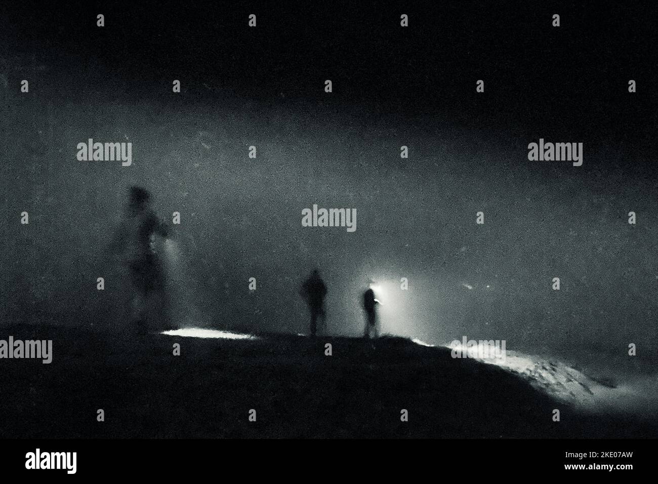 A spooky concept of blurred mysterious figures. Walking on a hill through fog. On an atmospheric ...