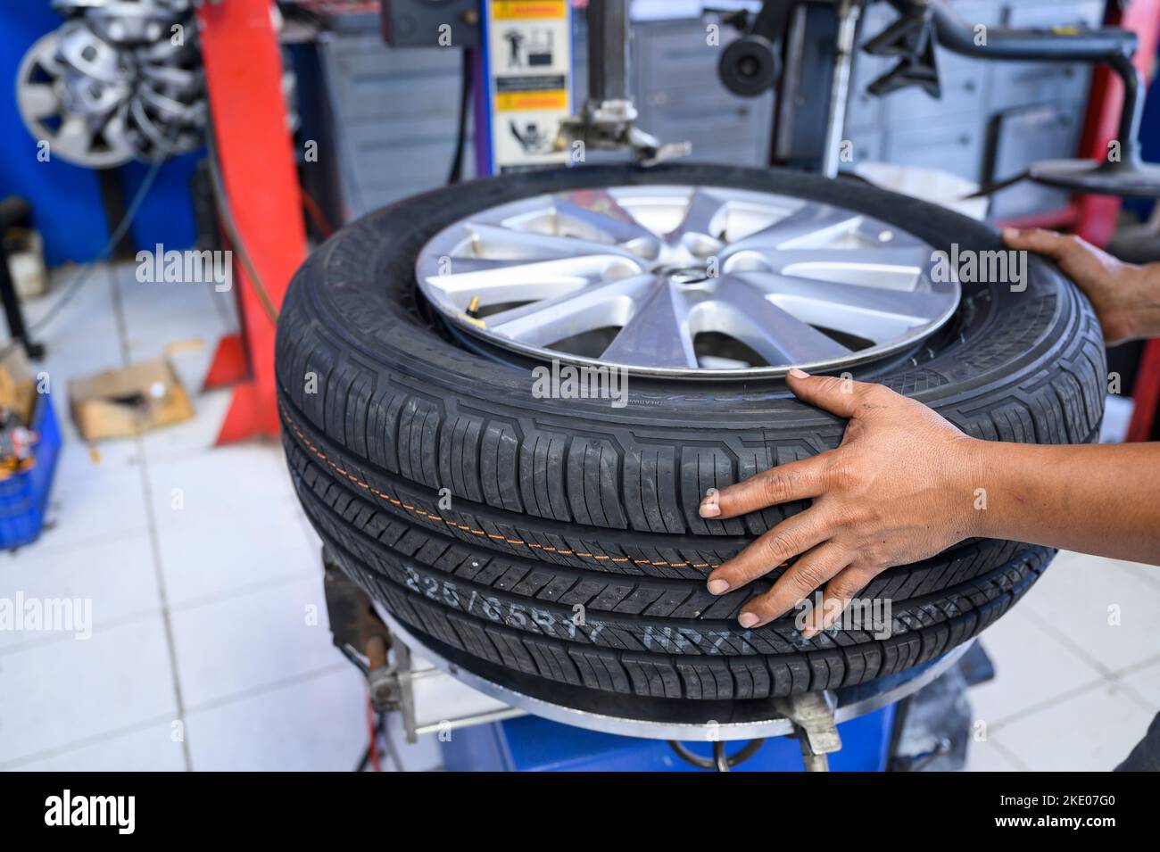 A mechanic replacing a tire on rim by machine Stock Photo - Alamy