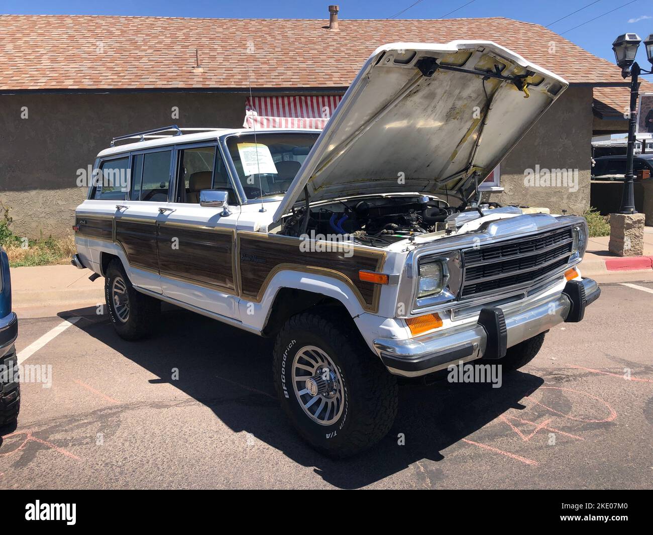 A beautiful classic Jeep Grand Cherokee with an open hood on the road ...