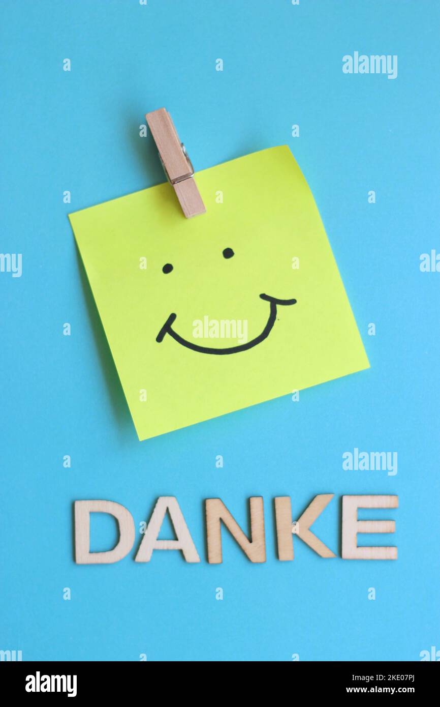 A smiley post-it with Danke text on a blue background Stock Photo - Alamy