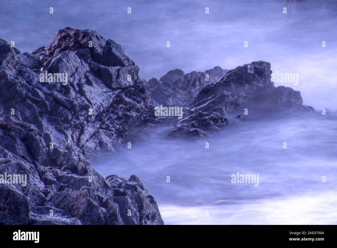 A long exposure of fog, mist on rocks, a purple background Stock Photo ...