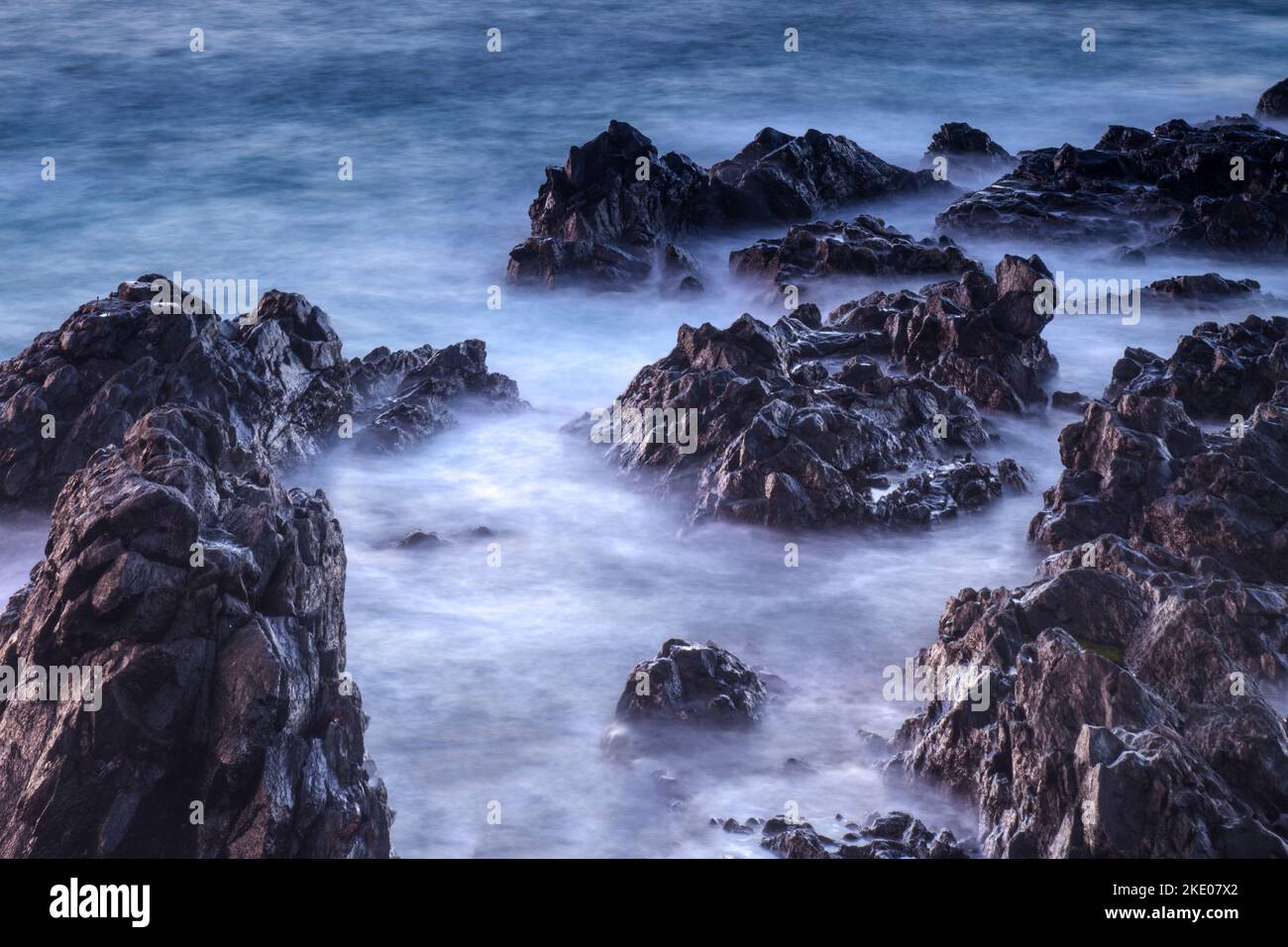 A long exposure of fog, mist on rocks, a purple background Stock Photo ...