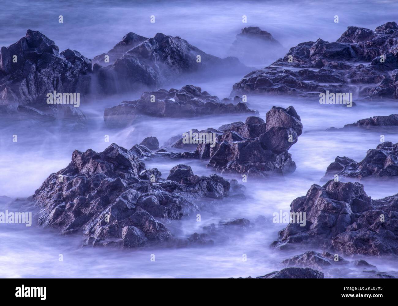 A long exposure of fog, mist on rocks, a purple background Stock Photo ...