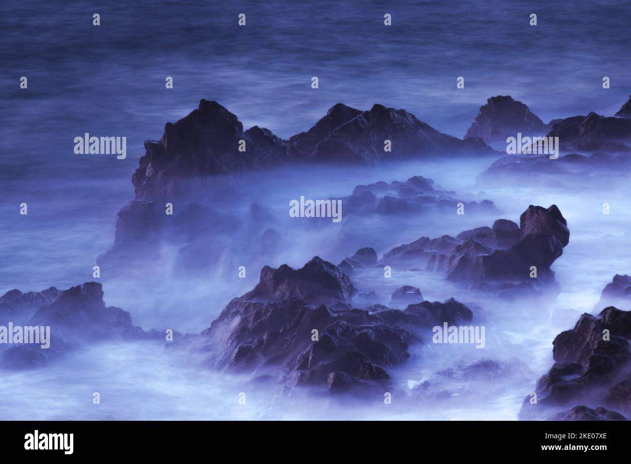 A long exposure of fog, mist on rocks, a purple background Stock Photo ...