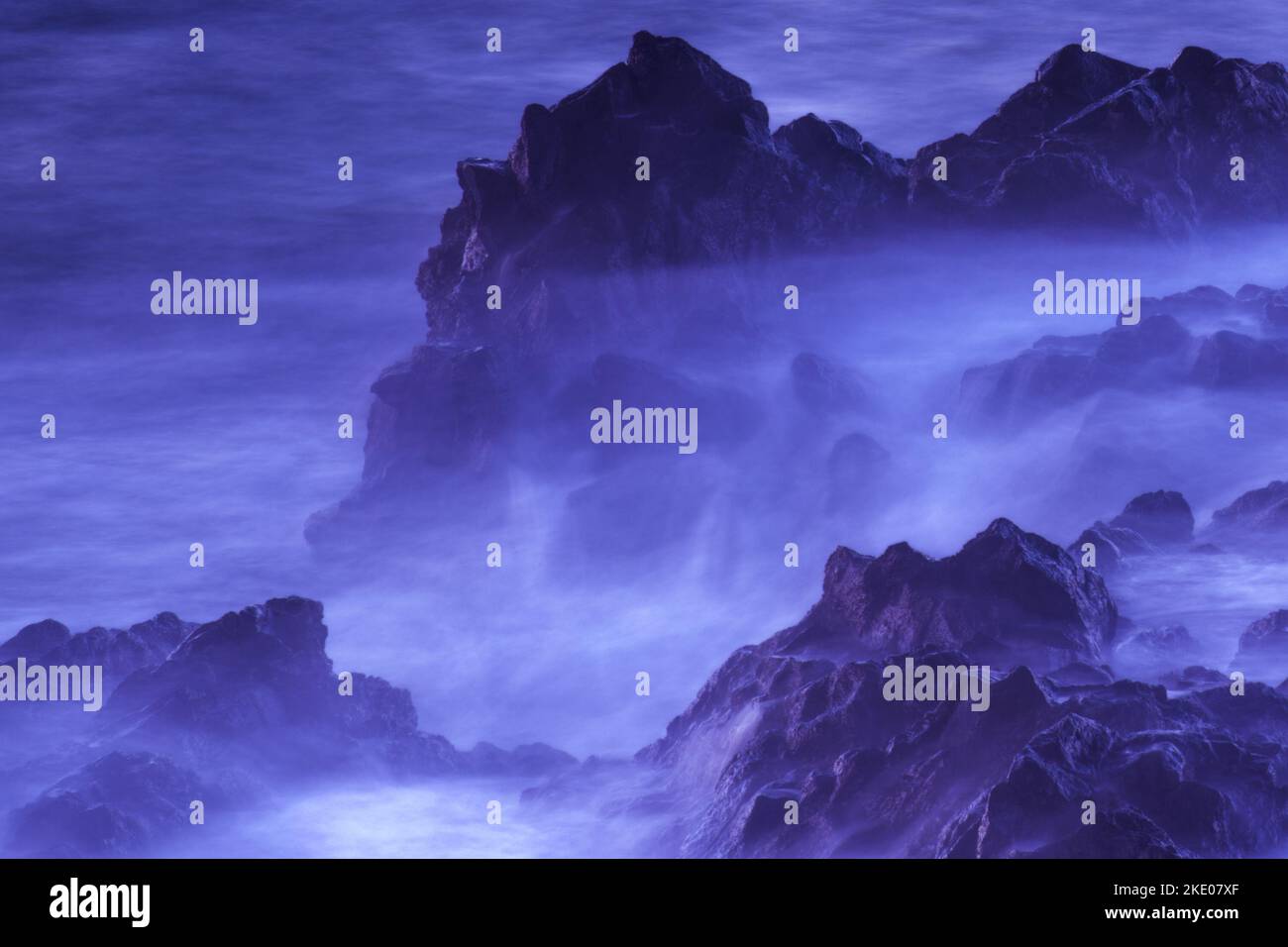 A long exposure of fog, mist on rocks, a purple background Stock Photo ...