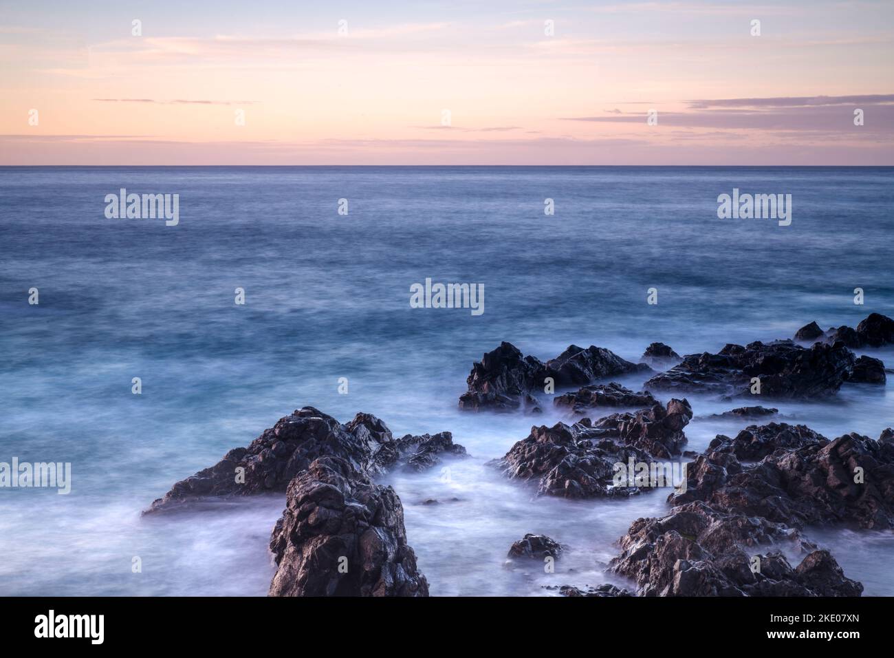 A long exposure of fog, mist on rocks, a purple background Stock Photo ...