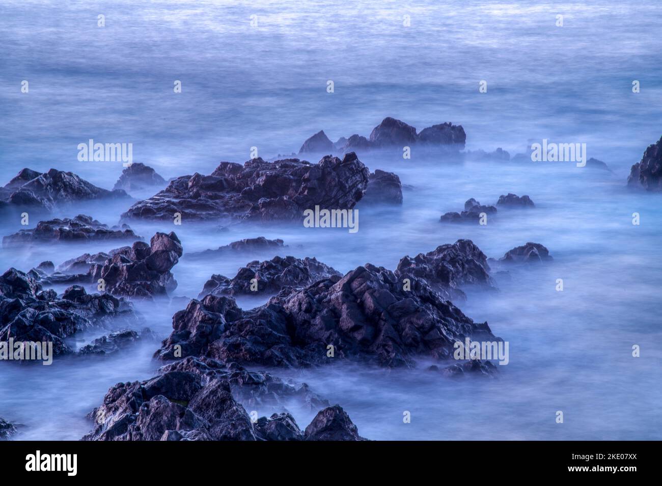 A long exposure of fog, mist on rocks, a purple background Stock Photo ...