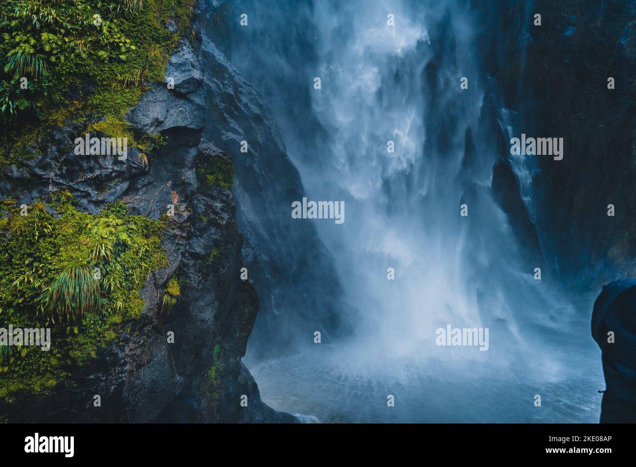 An aerial view of waterfall flowing from rocks surrounded by cliffs ...