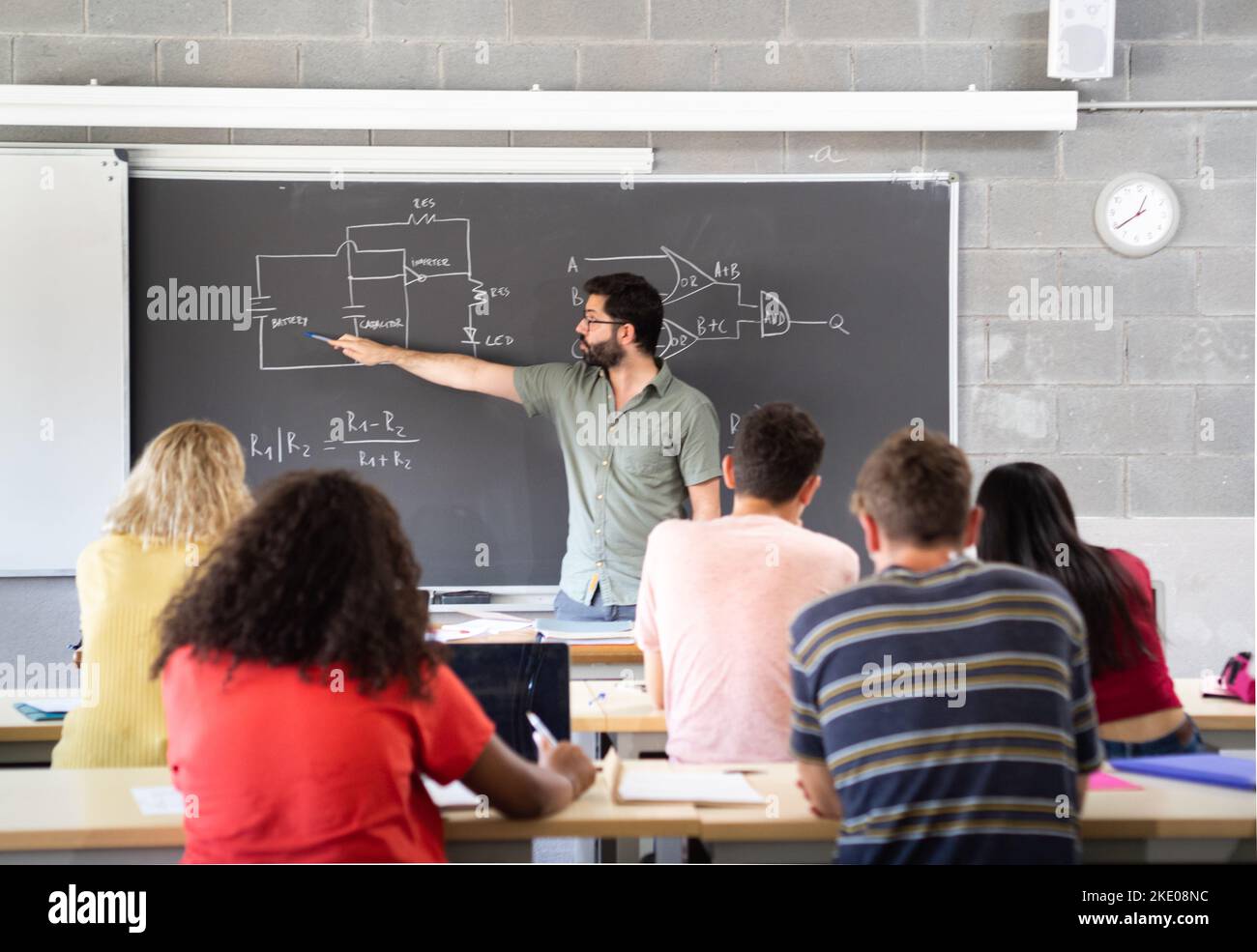 A professor explaining the lesson while students attentively listen ...