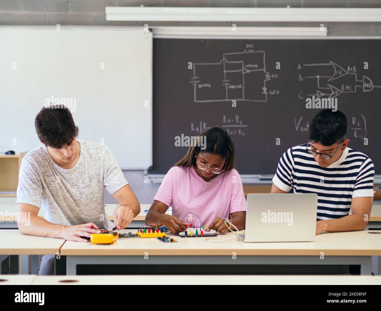 A group of students attentively working on a project together in a ...