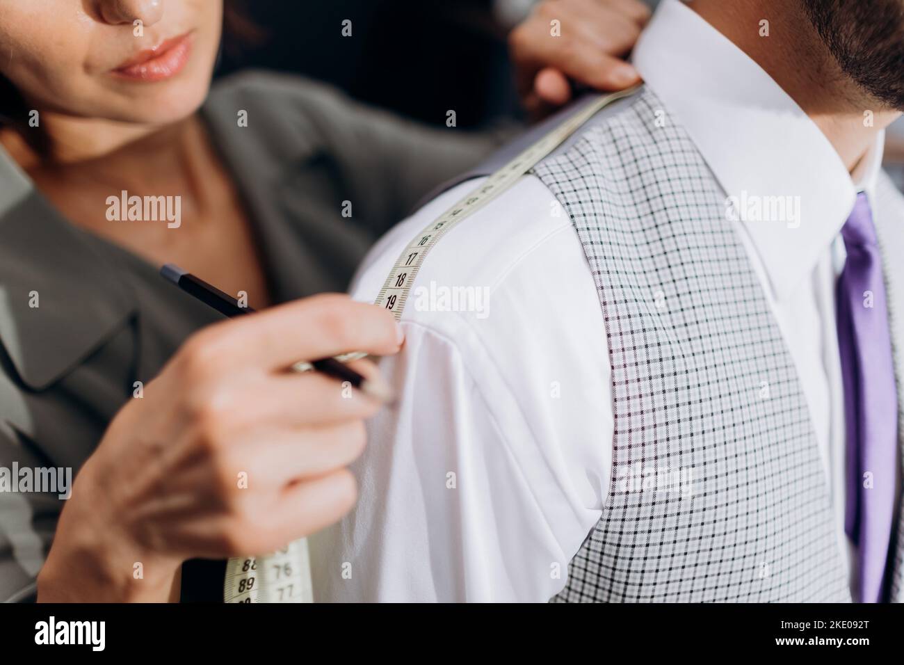 Tailor measuring client at work Stock Photo - Alamy