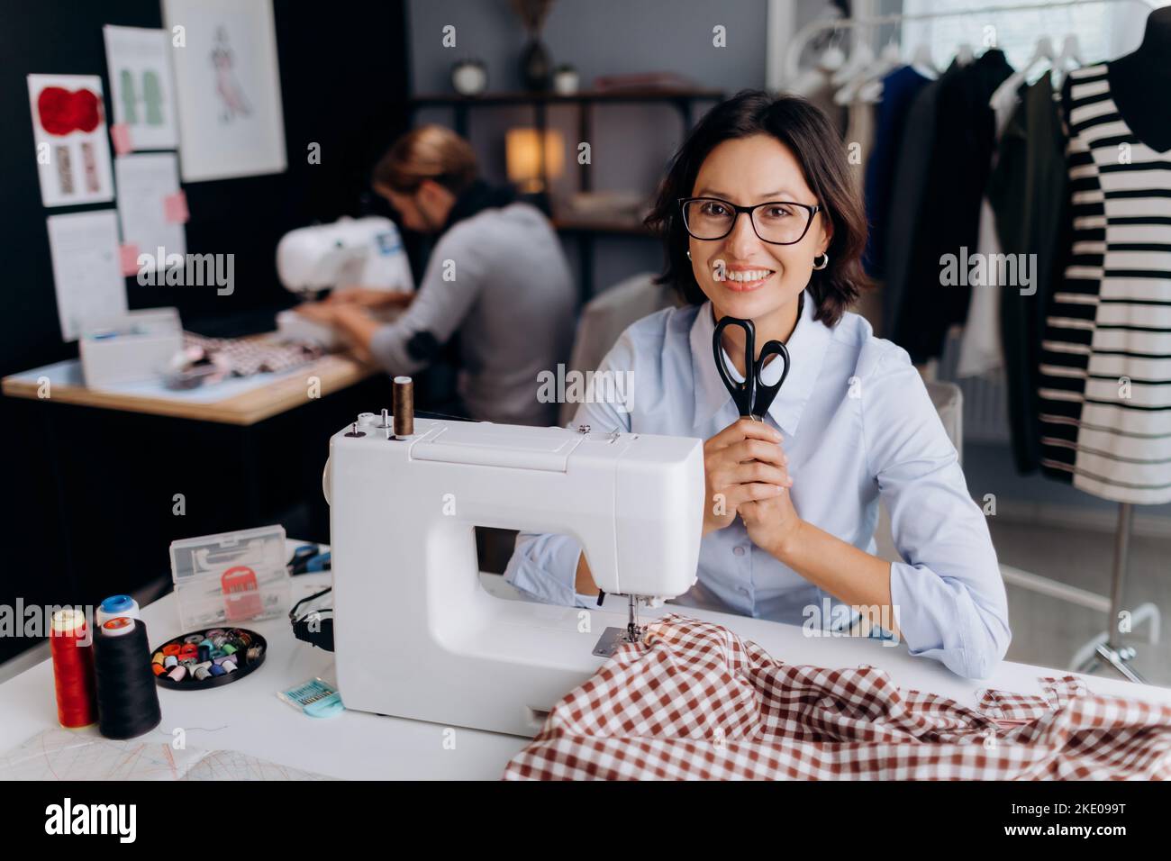 Seamstress with sewing machine at work Stock Photo - Alamy