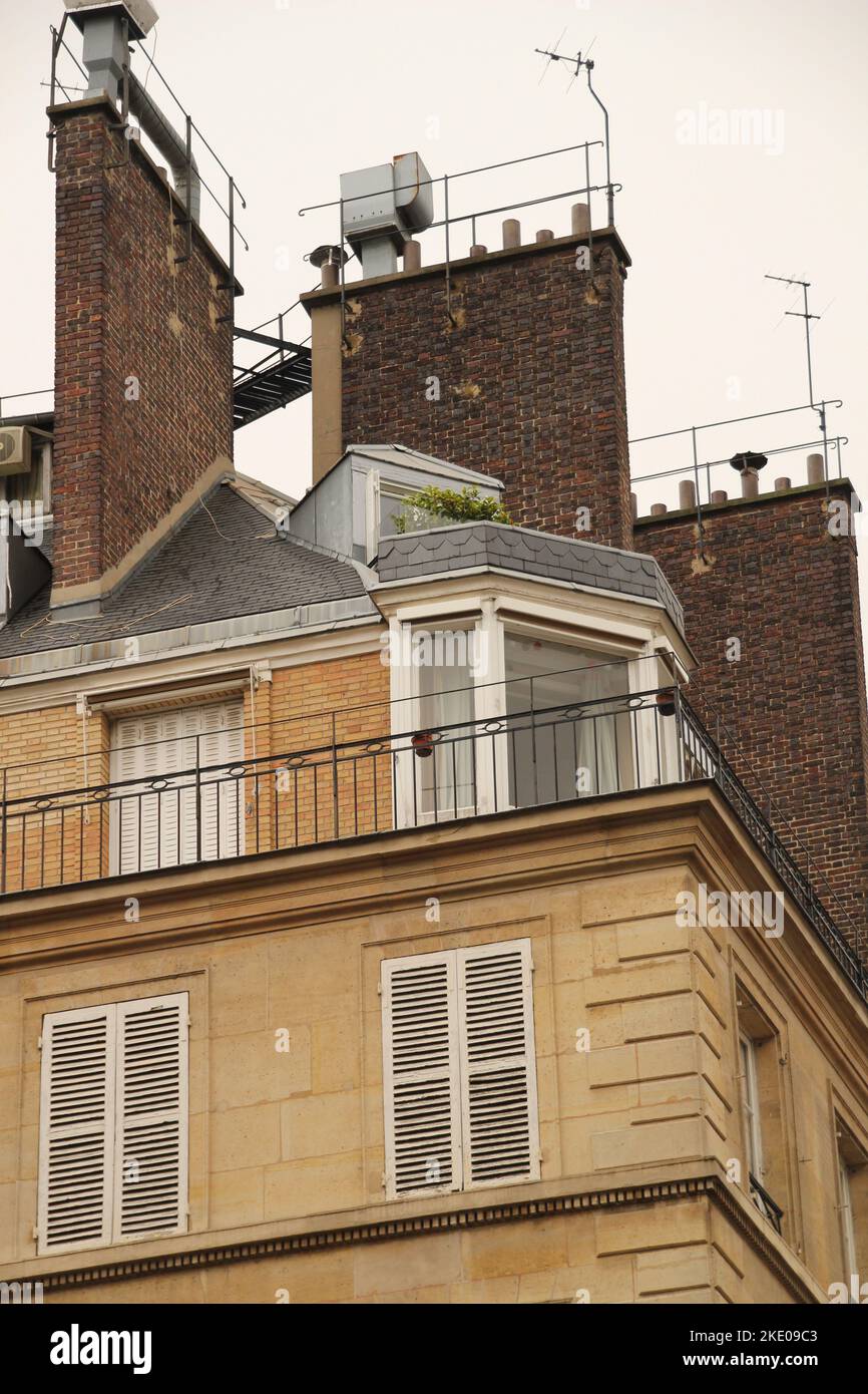 A vertical shot of a building facade and the roof with a cloudy sky in ...