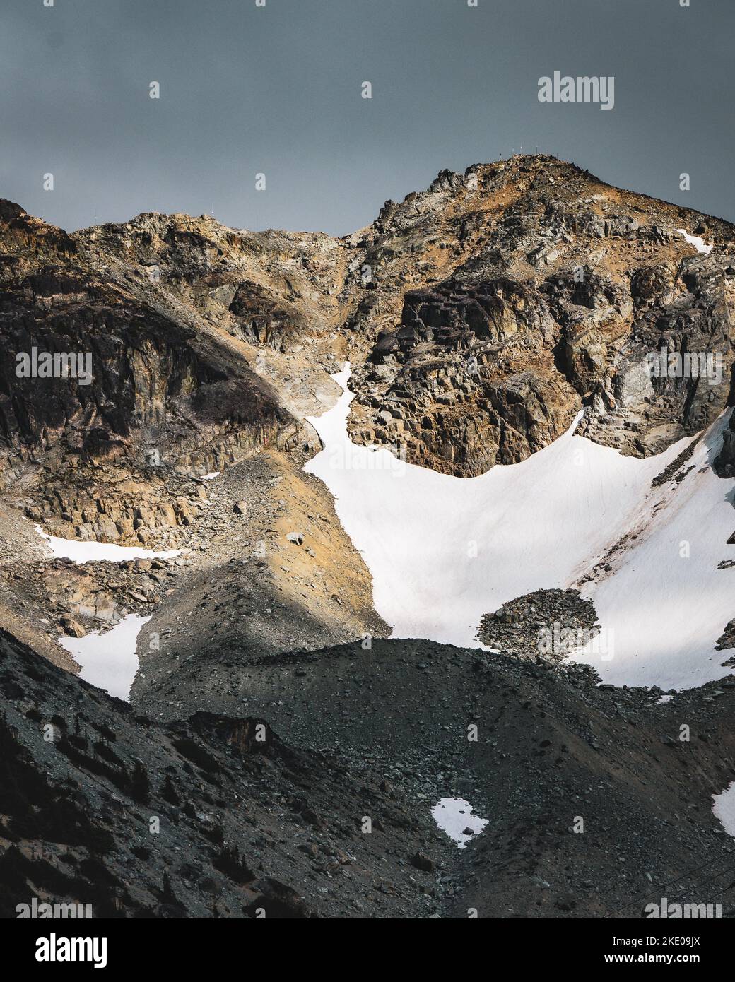 A vertical shot of rocky mountain with melting snow Stock Photo - Alamy