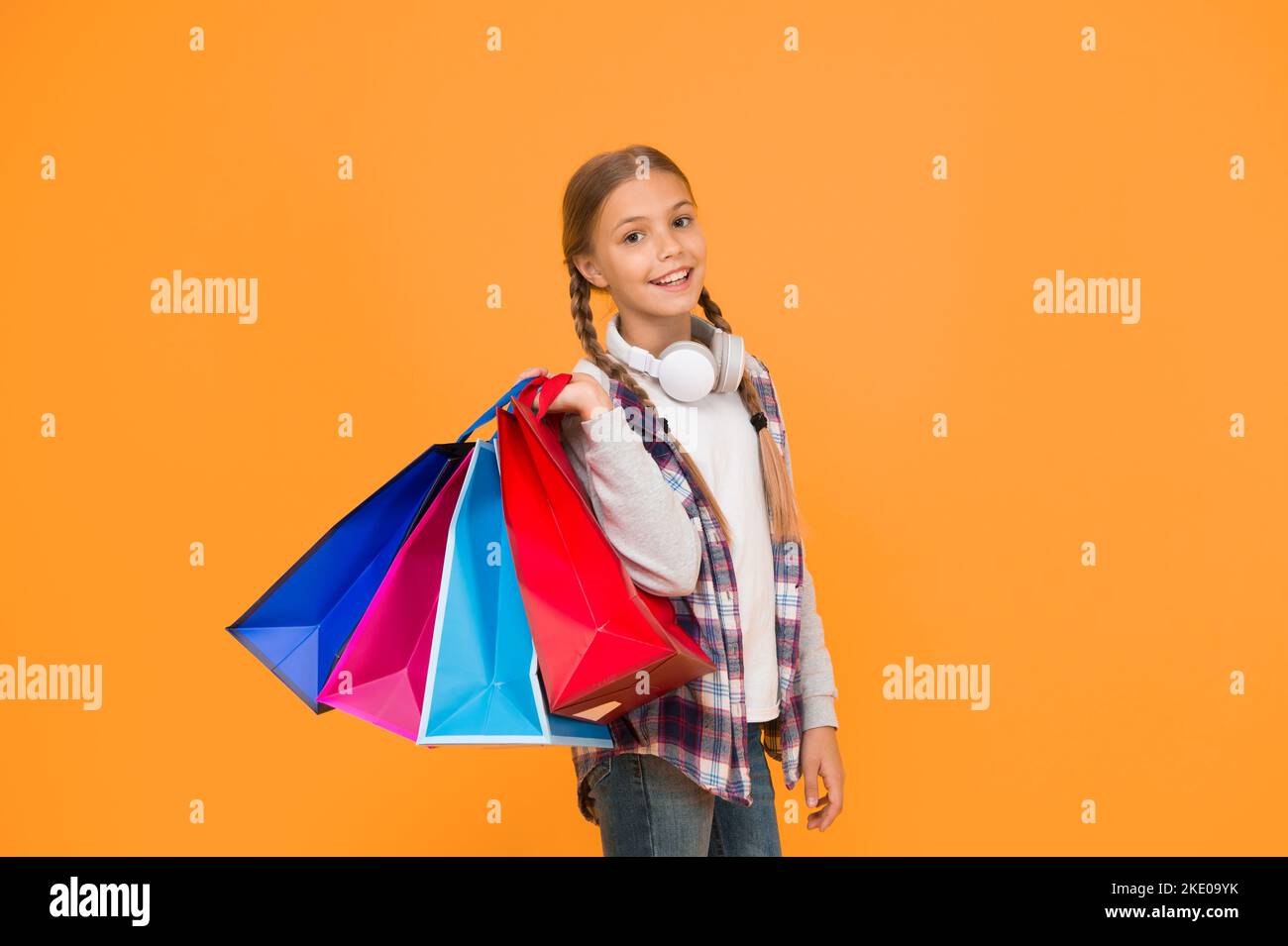 Dive into shopping. Happy child with paper bags. Little girl smile with ...