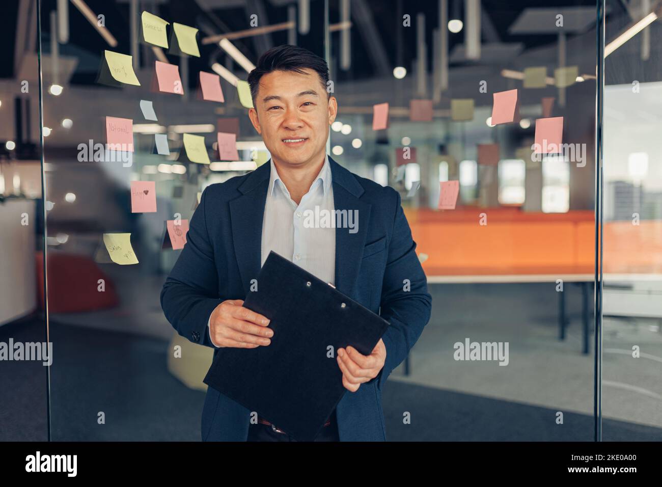 Portrait of handsome asian businessman in suit standing in office and ...