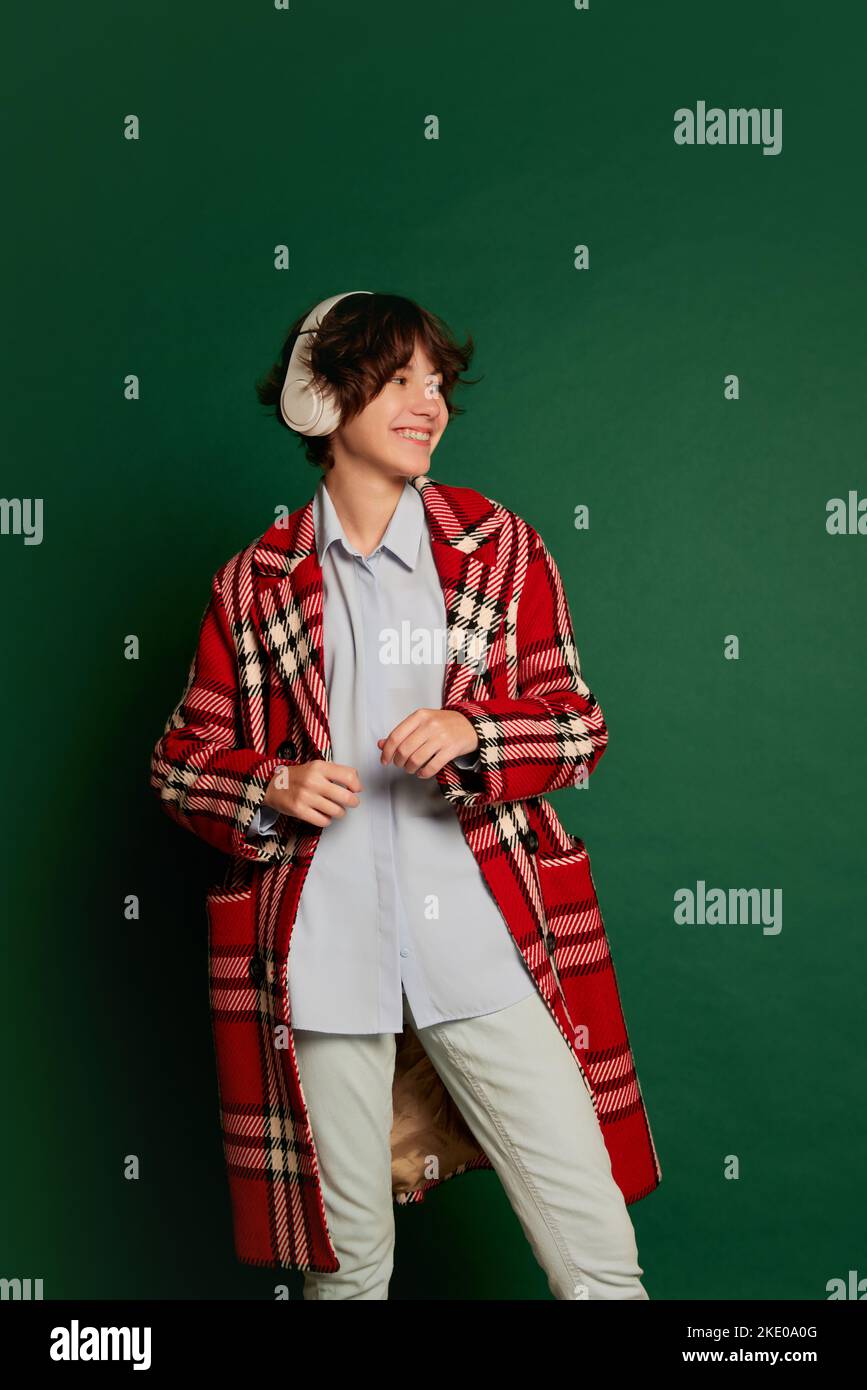 Portrait of cheerful teen girl with curly brown short hair posing in ...