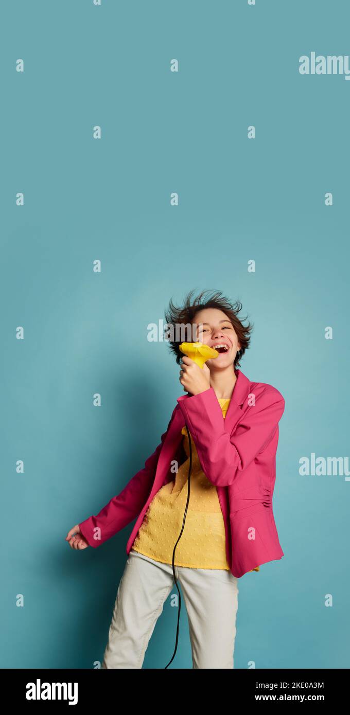 Portrait of cheerful teen girl with curly brown short hair posing with ...