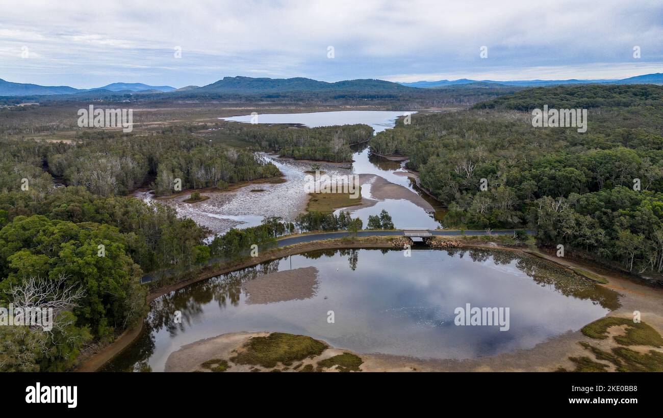 An aerial shot of the Lake Cathie surrounded by lush trees in New South ...