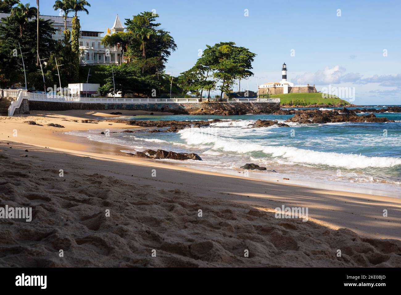A landscape of a sandy beach and the Barra Lighthouse from afar in ...