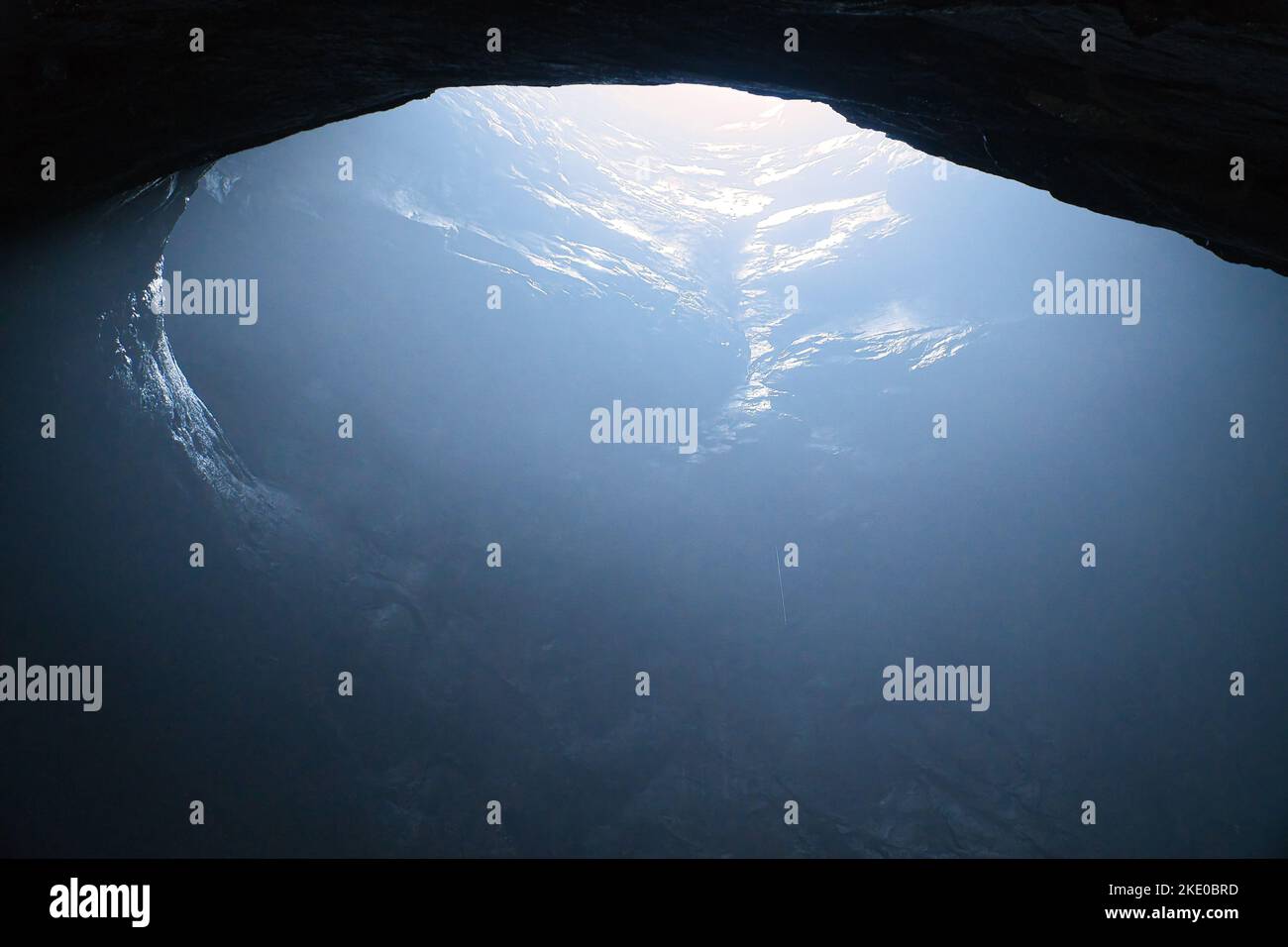 Rock cave with hole through which light shines. Underworlds in Sweden ...