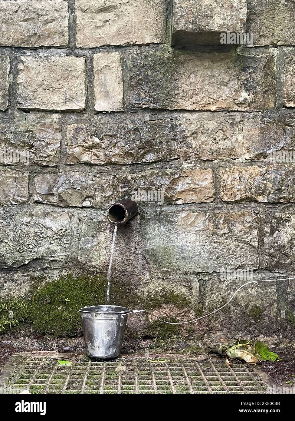 A vertical shot of a water running pipe fixed on the wall and a metal ...